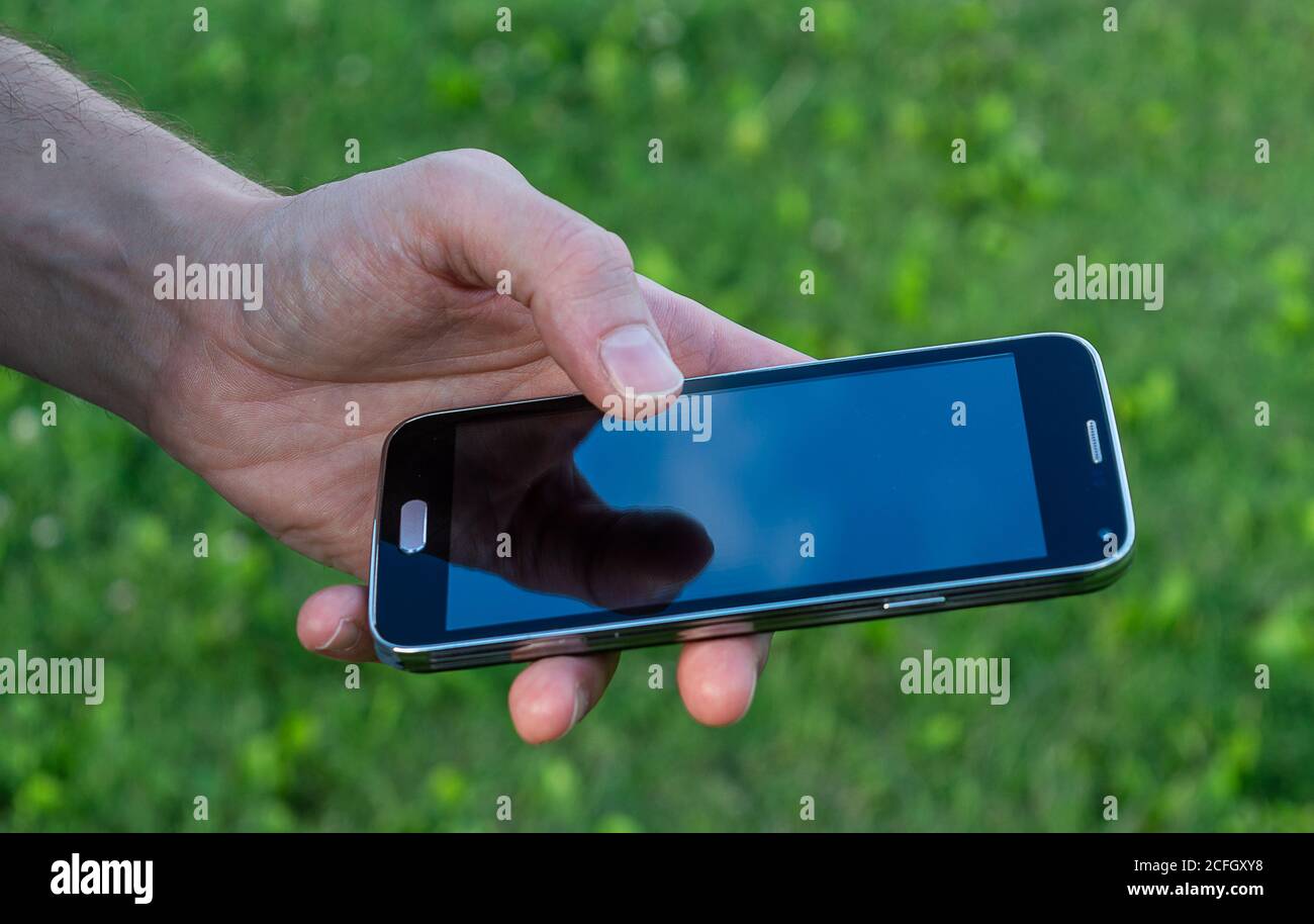 man hand holding mobile phone reflection on screen Stock Photo - Alamy