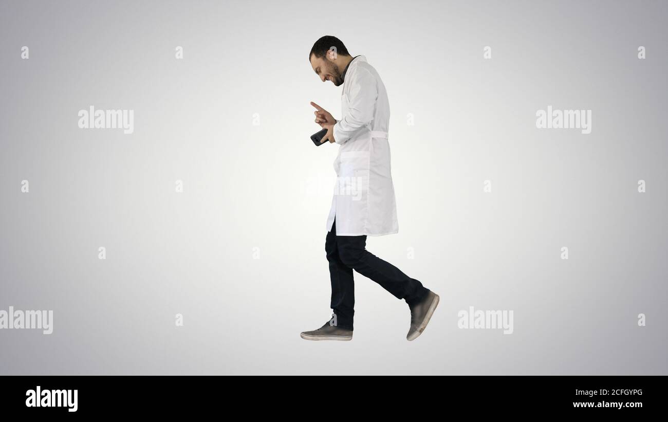 Walking attractive laughing doctor on gradient background Stock Photo ...
