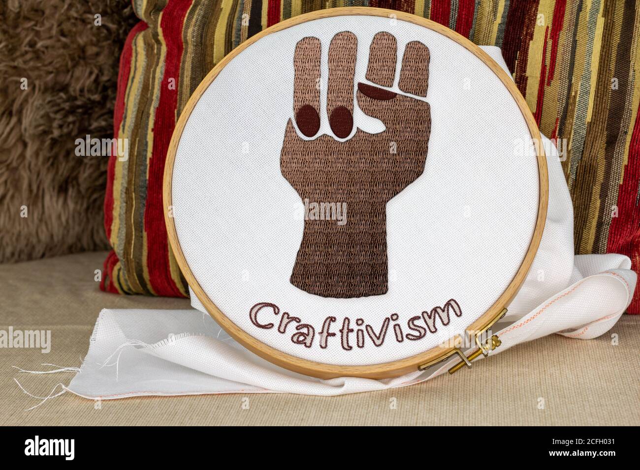 Black embroidered raised power fist on sewing hoop, activism through ...