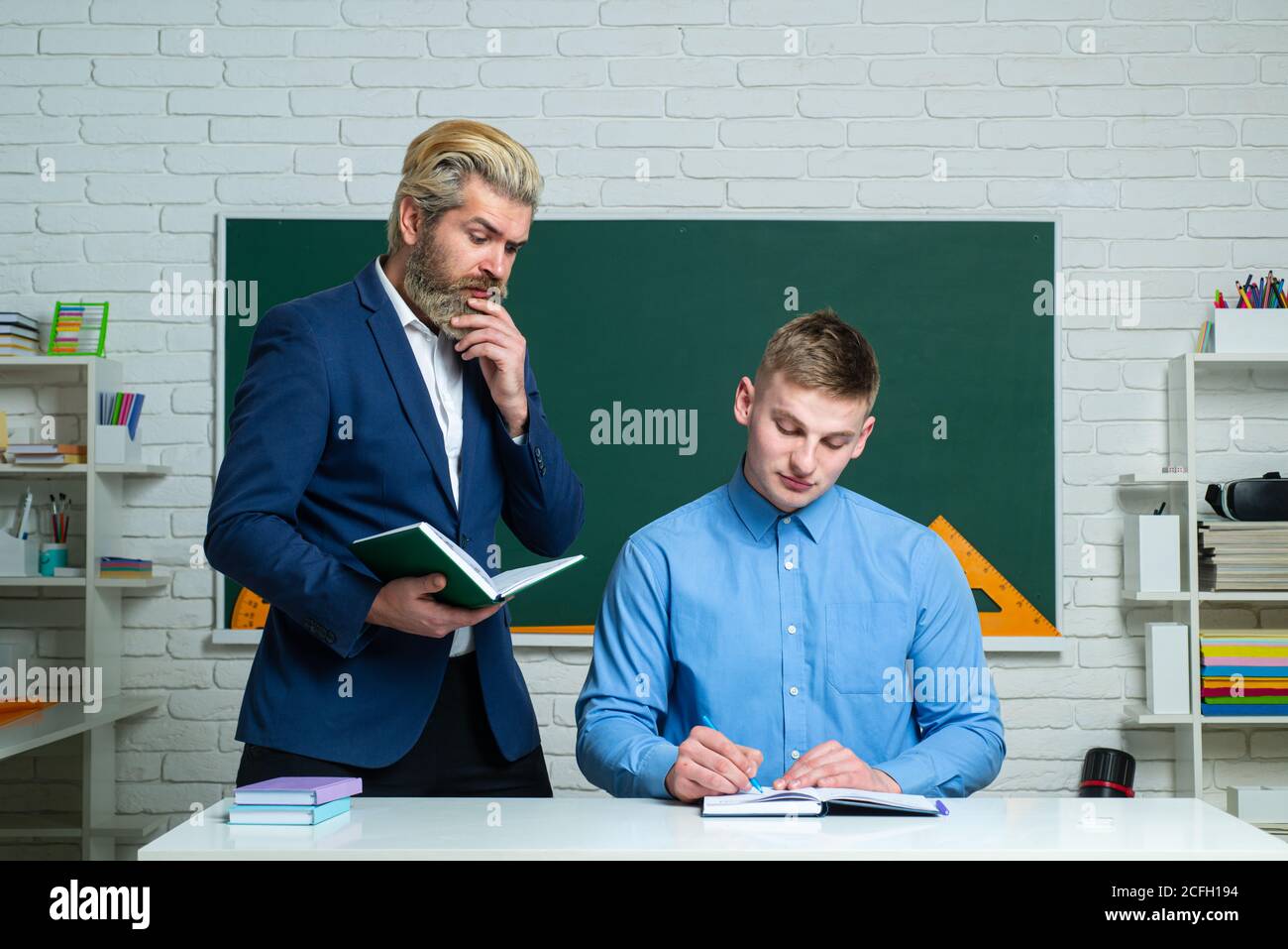 Student and teacher. Teacher helping students with assignment Stock ...