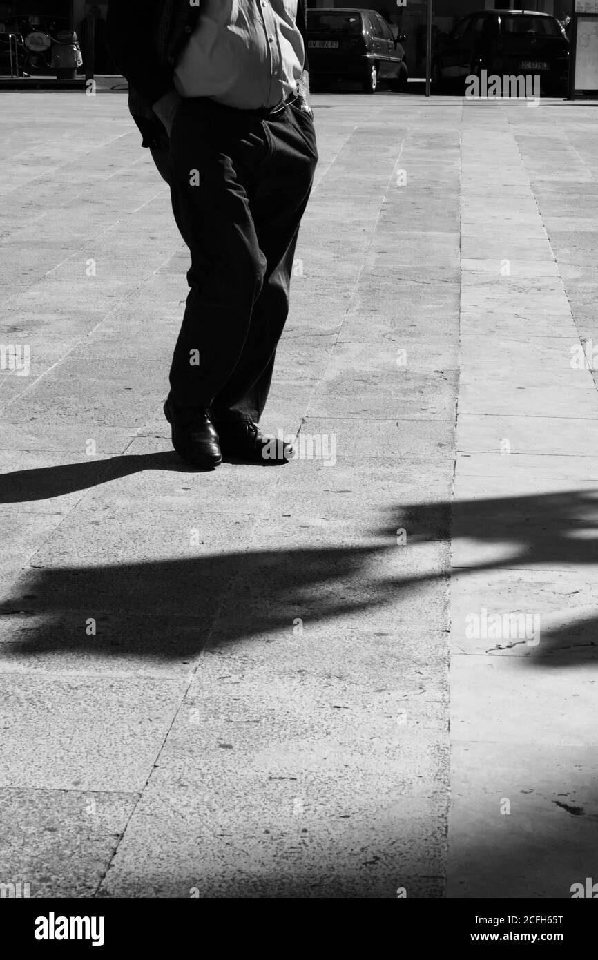 Sicilian man in a square with his hands in his pockets with elongated ...