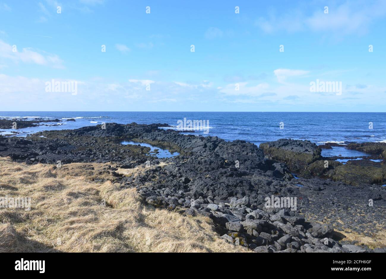 Coastal seascape with deep blue ocean and black lava rock Stock Photo ...
