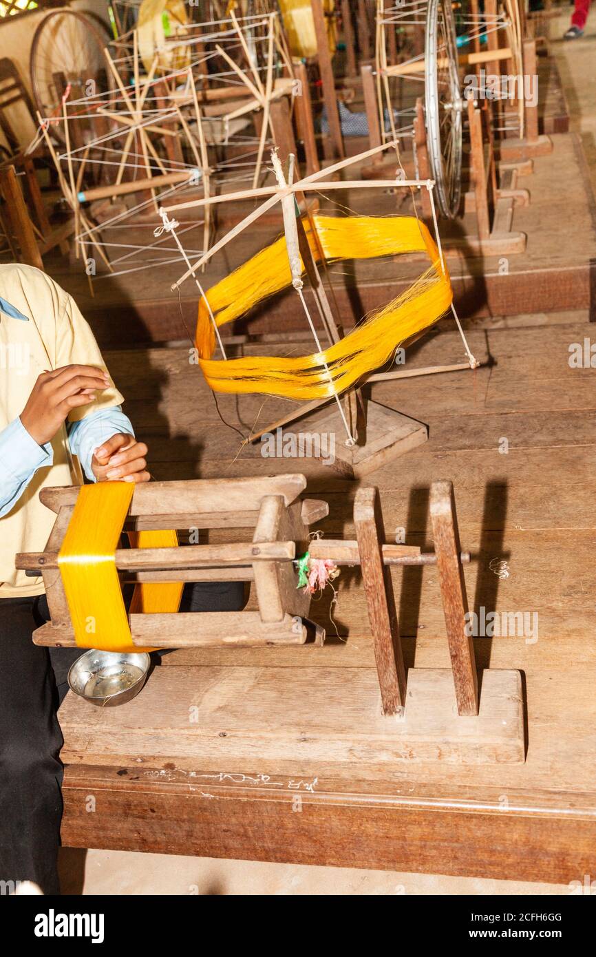 drawing fine silk from raw, scene in silk factory in Cambodia. Silk ...