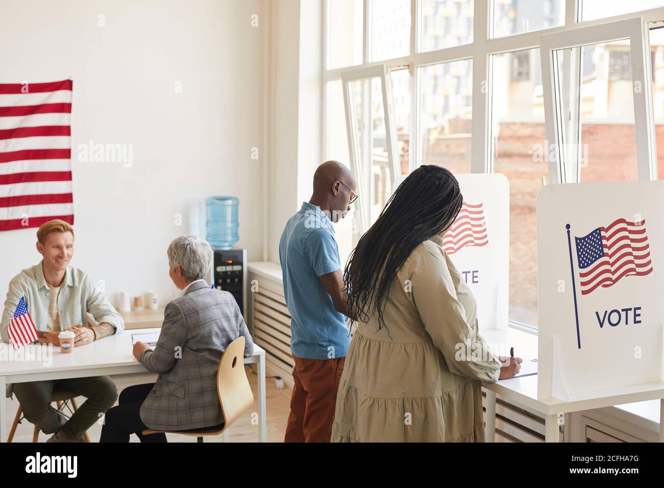 Wide angle view at polling station on election day, focus on two people ...