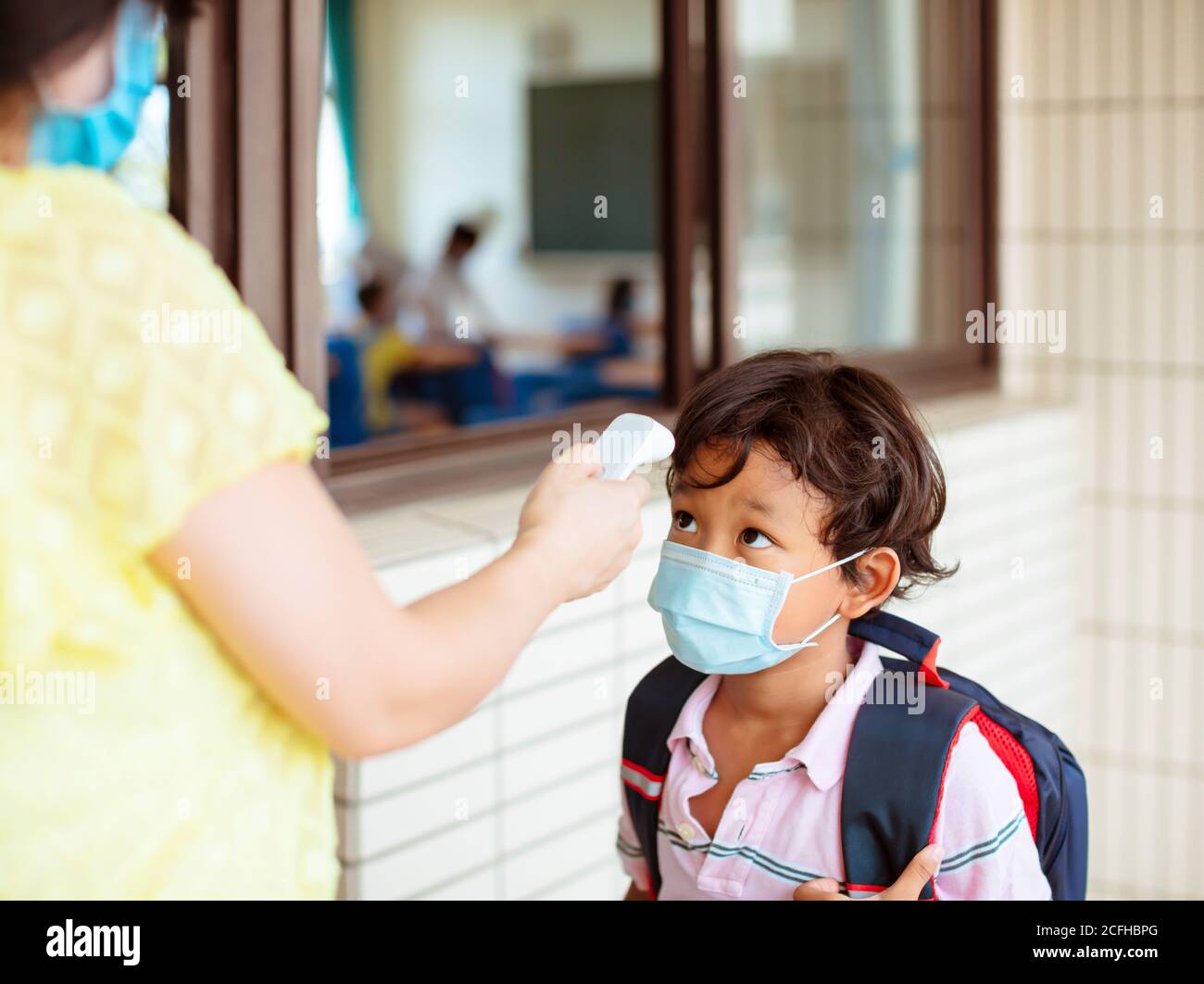 Temperature and medical check at school for covid-19 Stock Photo - Alamy