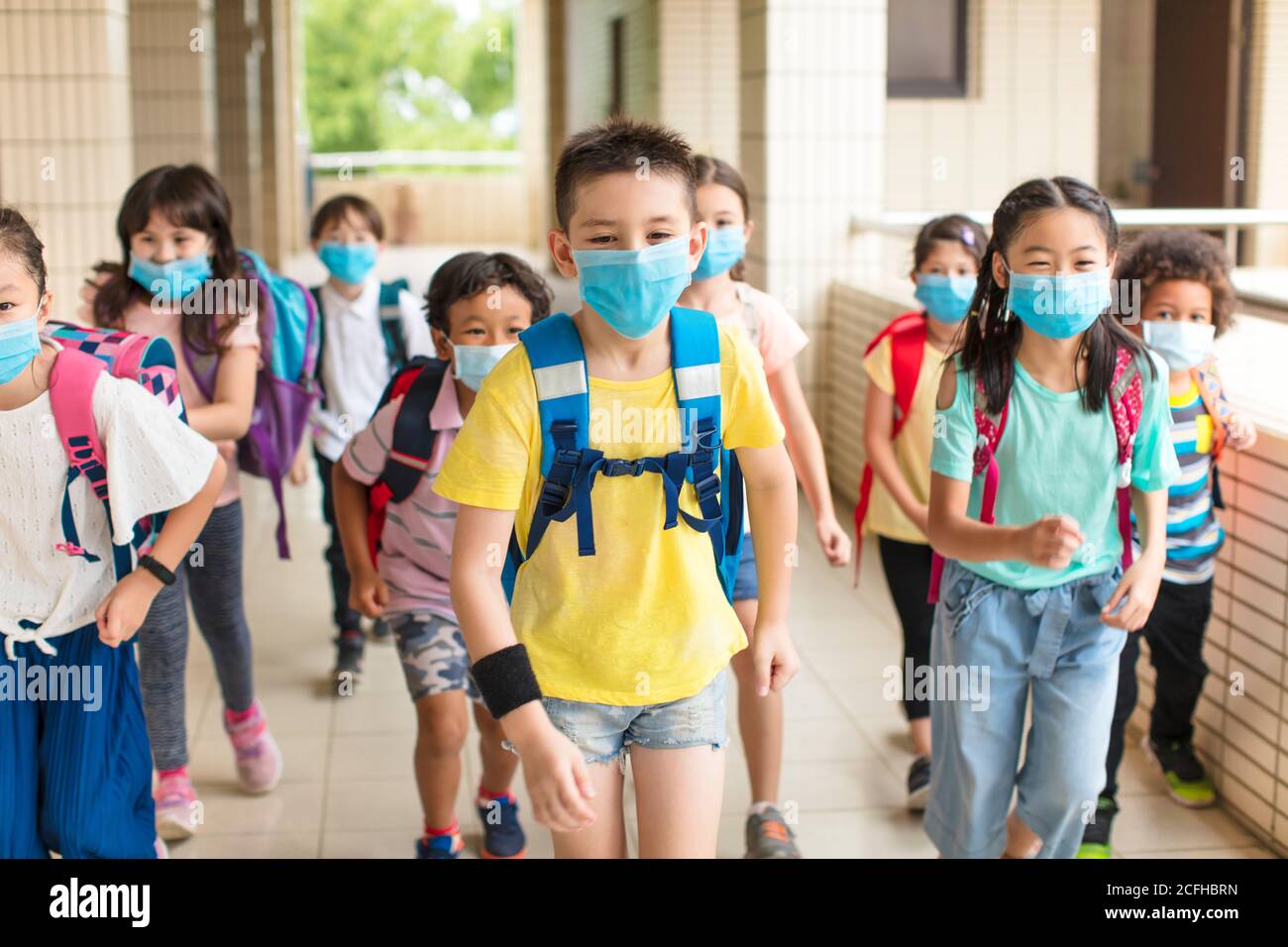 Group of children wearing face mask back at school after covid-19 ...