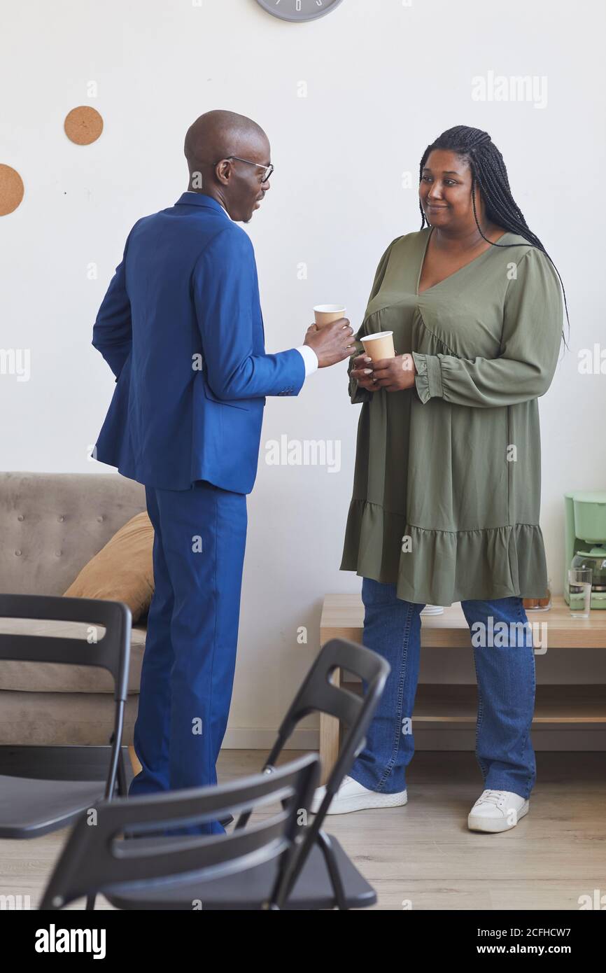 Vertical full length portrait of two African-American people talking ...