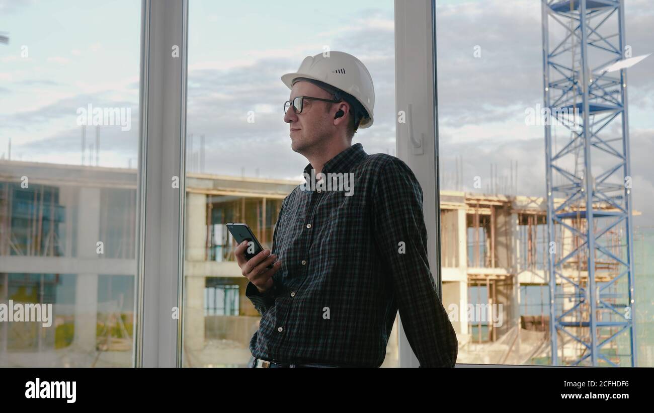 Construction worker listening to music from his phone with wirel Stock ...