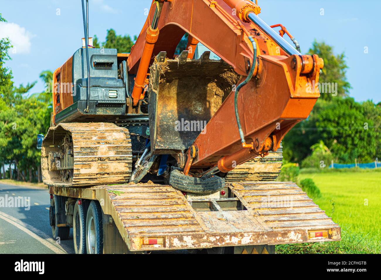 Backhoe excavator on truck on the road between transport Stock Photo ...