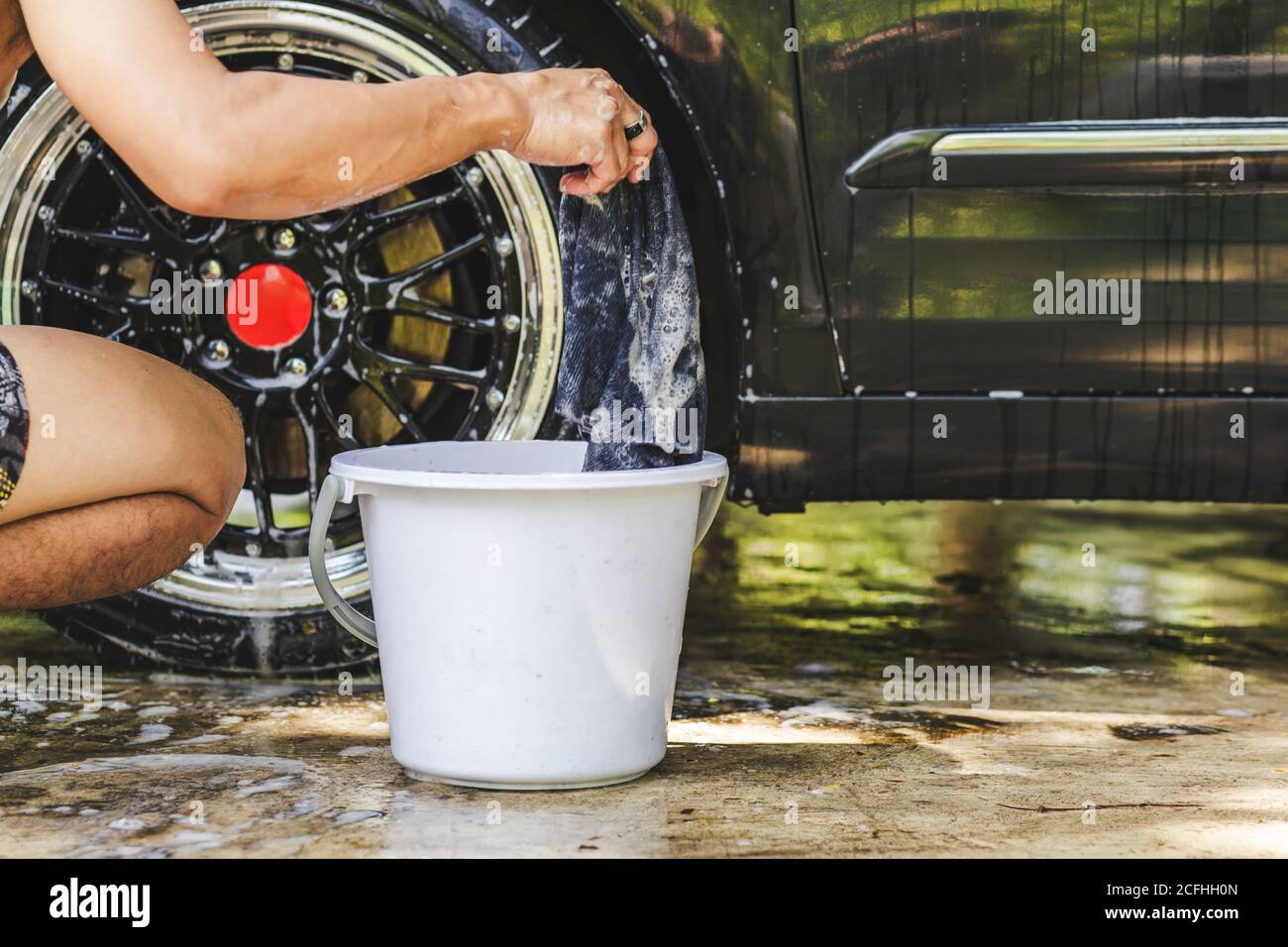 male hand with foam fabric washing car wheel Cleaning Wheels Use Water ...