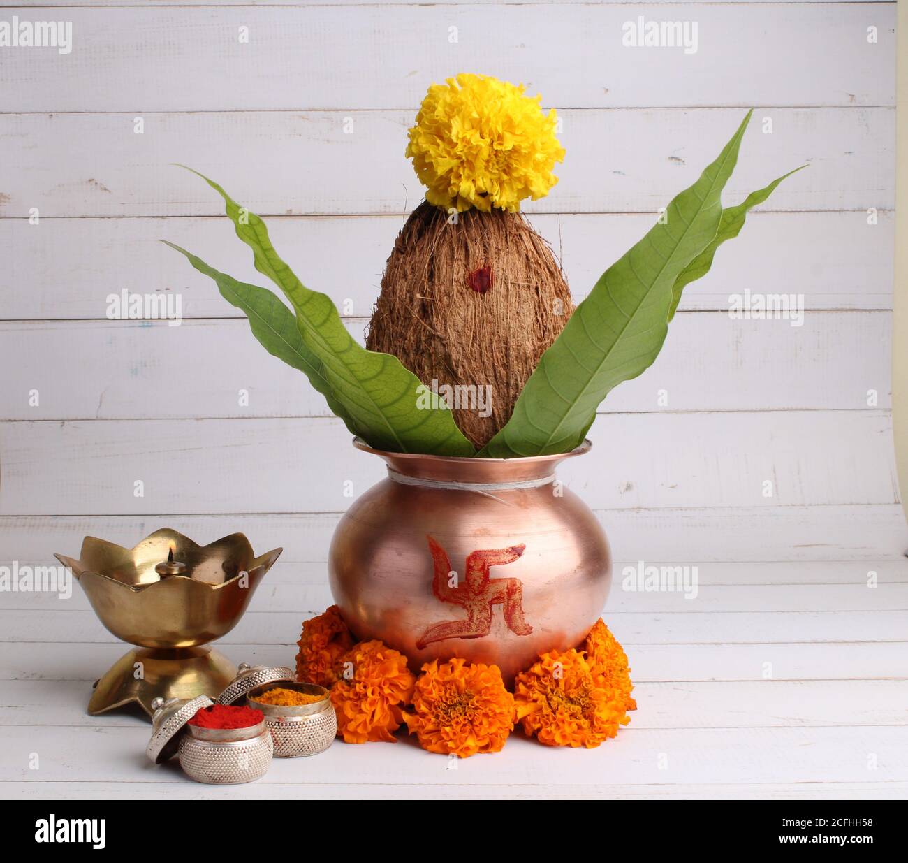 copper kalash with coconut and mango leaf with haldi kumkum, diya and ...