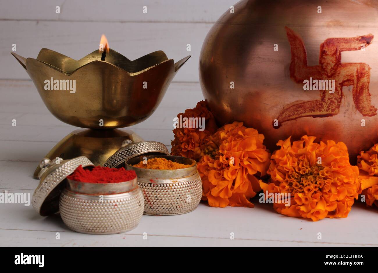 copper kalash with coconut and mango leaf with haldi kumkum, diya and ...