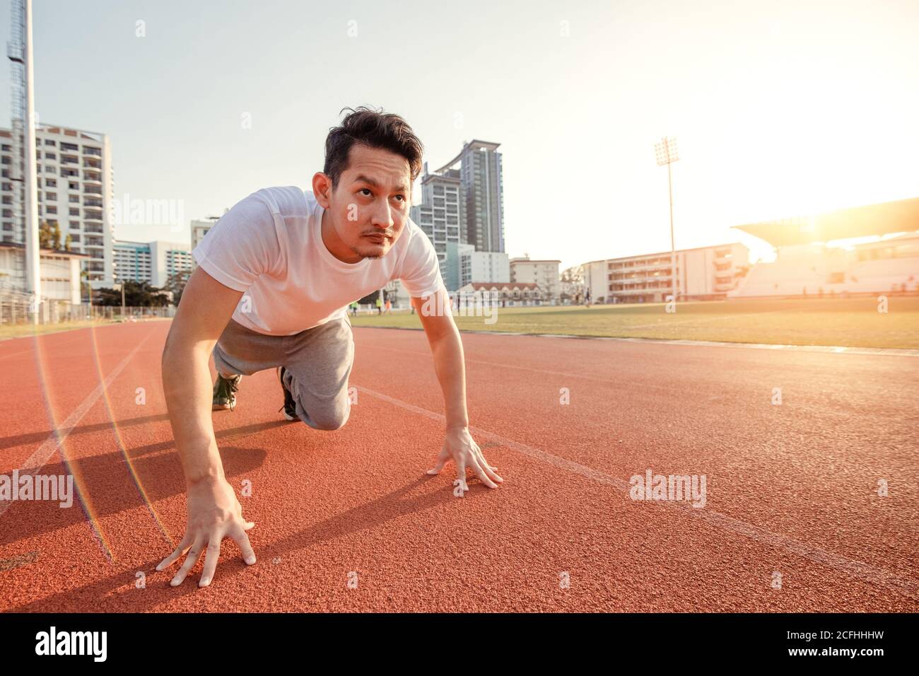 Hands on track race at sport stadium. A man prepare for start running ...