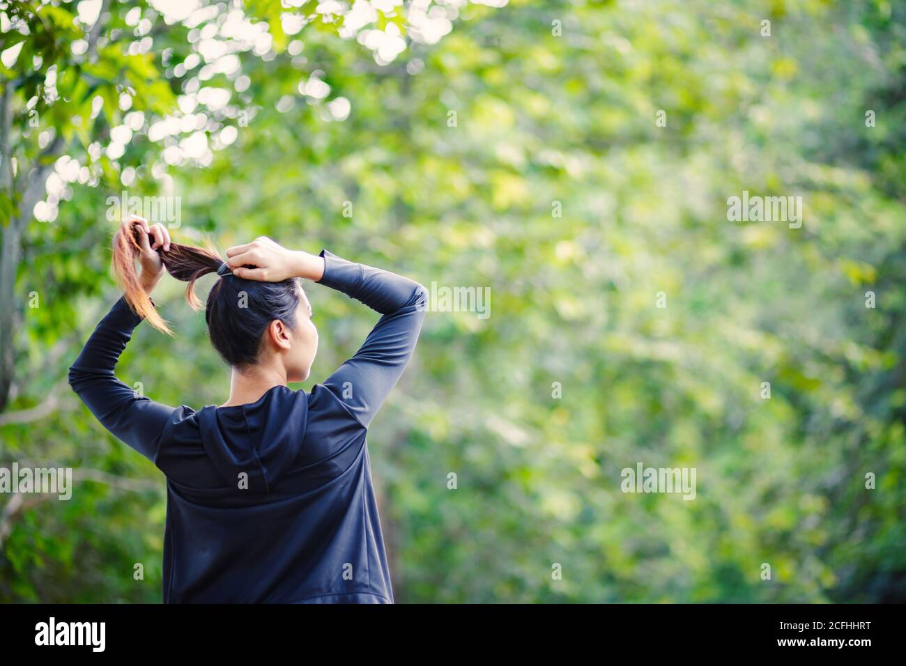 Beautiful women bundle of hair ner big tree Stock Photo - Alamy