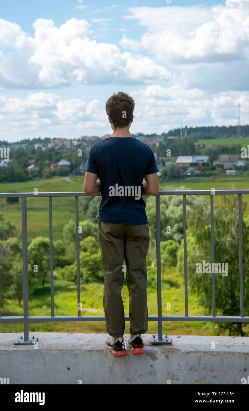 Young man standing railing observation hi-res stock photography and ...