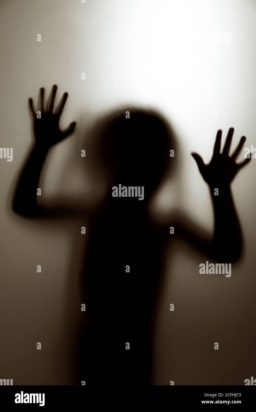 Ghost concept shadow of a child behind the matte glass blurry hand and ...