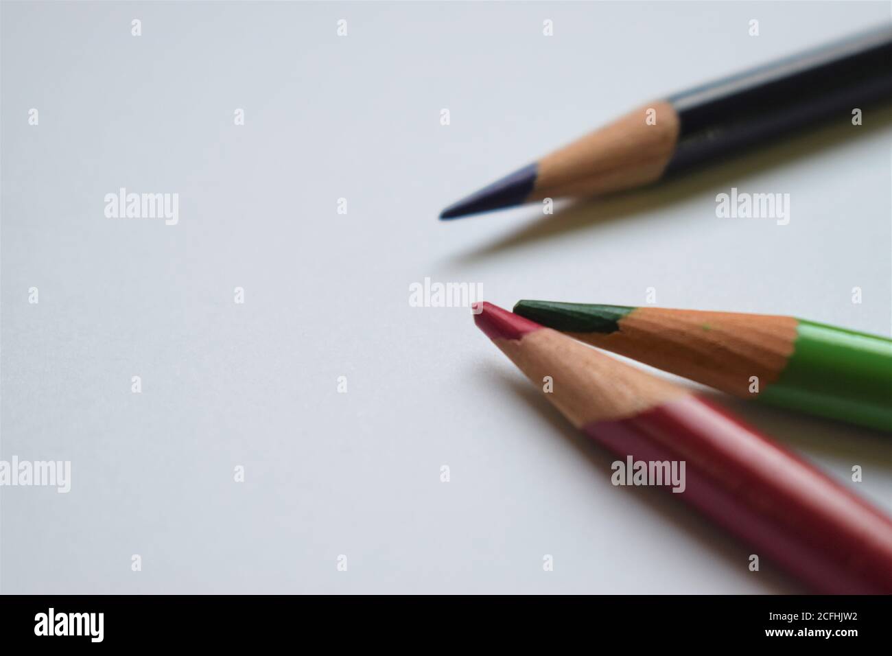 Sharp colored pencils arranged on a white background with copy space ...
