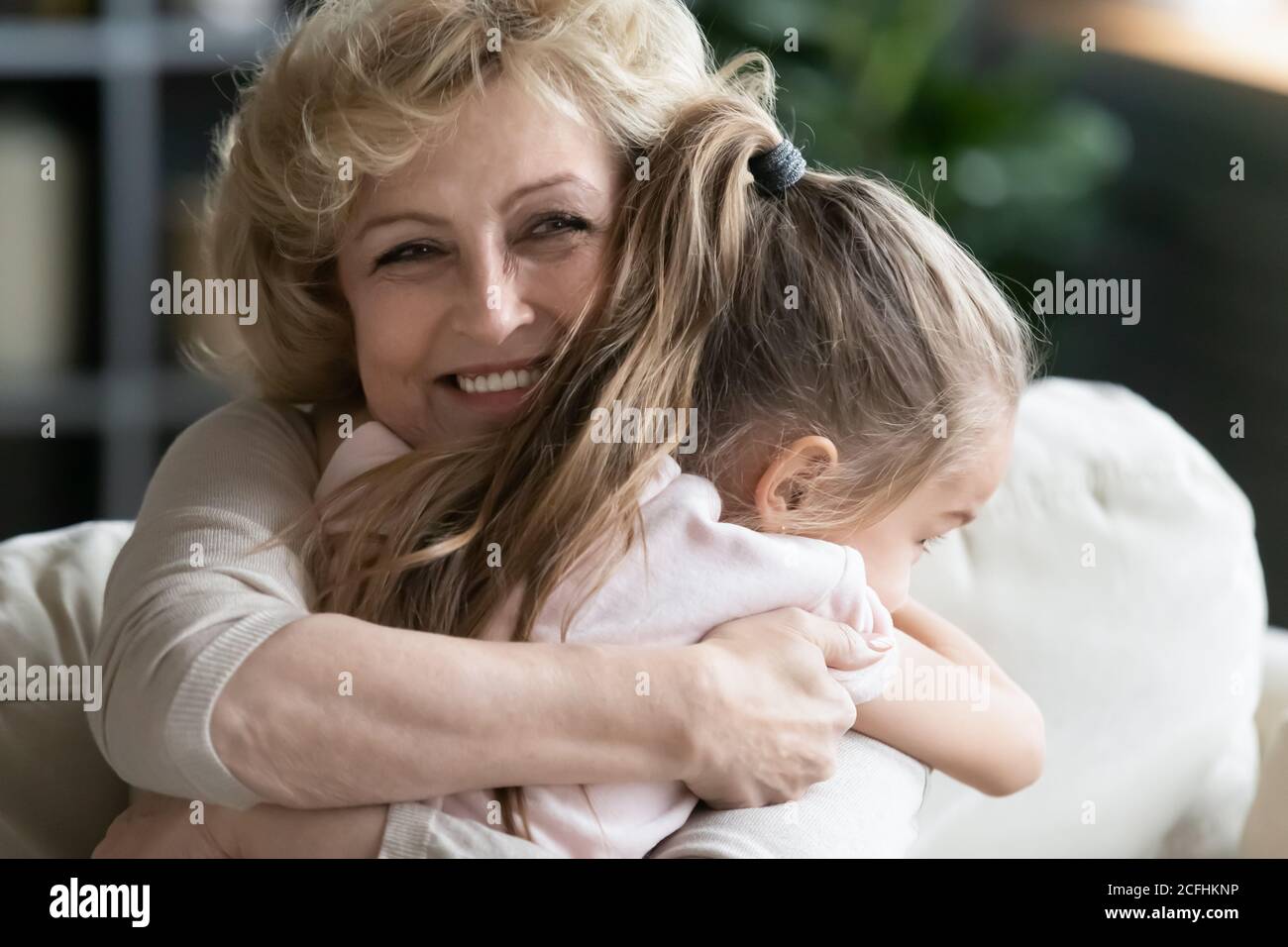 Close up smiling loving mature woman hugging little granddaughter Stock ...