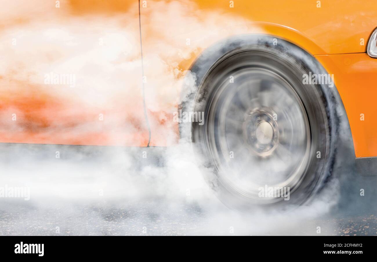 Drag racing car burns rubber off its tire in preparation for the race ...