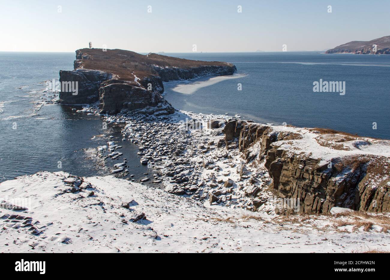 Rocks covered with snow at the tip of Tobizin cape on the Russian ...