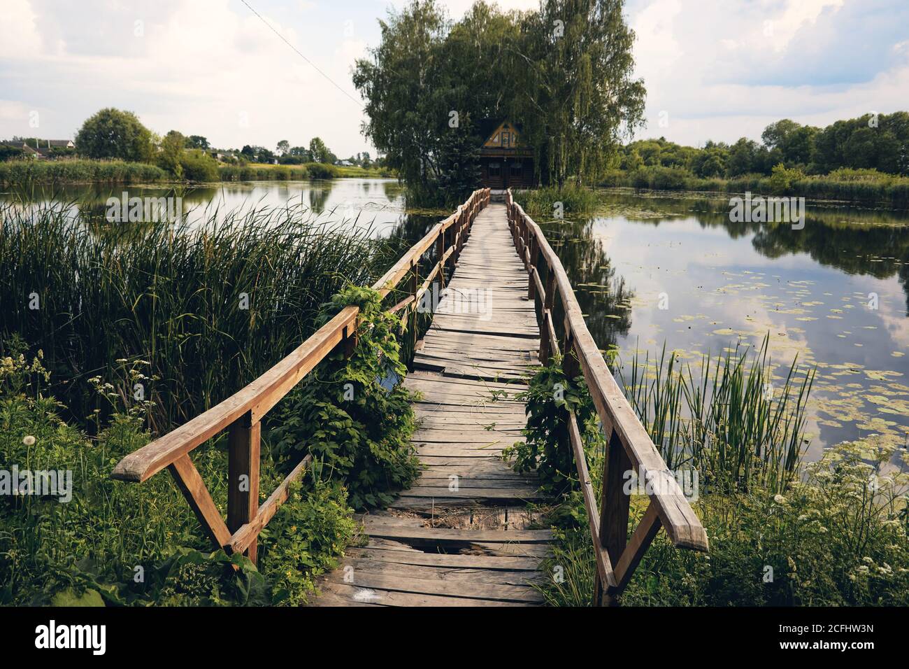 Landscape view of Old small wooden bridge across the lake. Fishman ...
