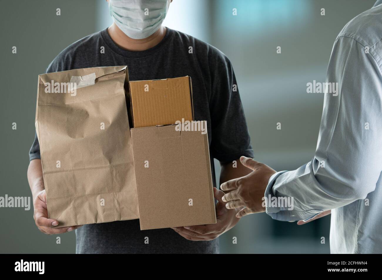 Delivery man in protective mask hi-res stock photography and images - Alamy