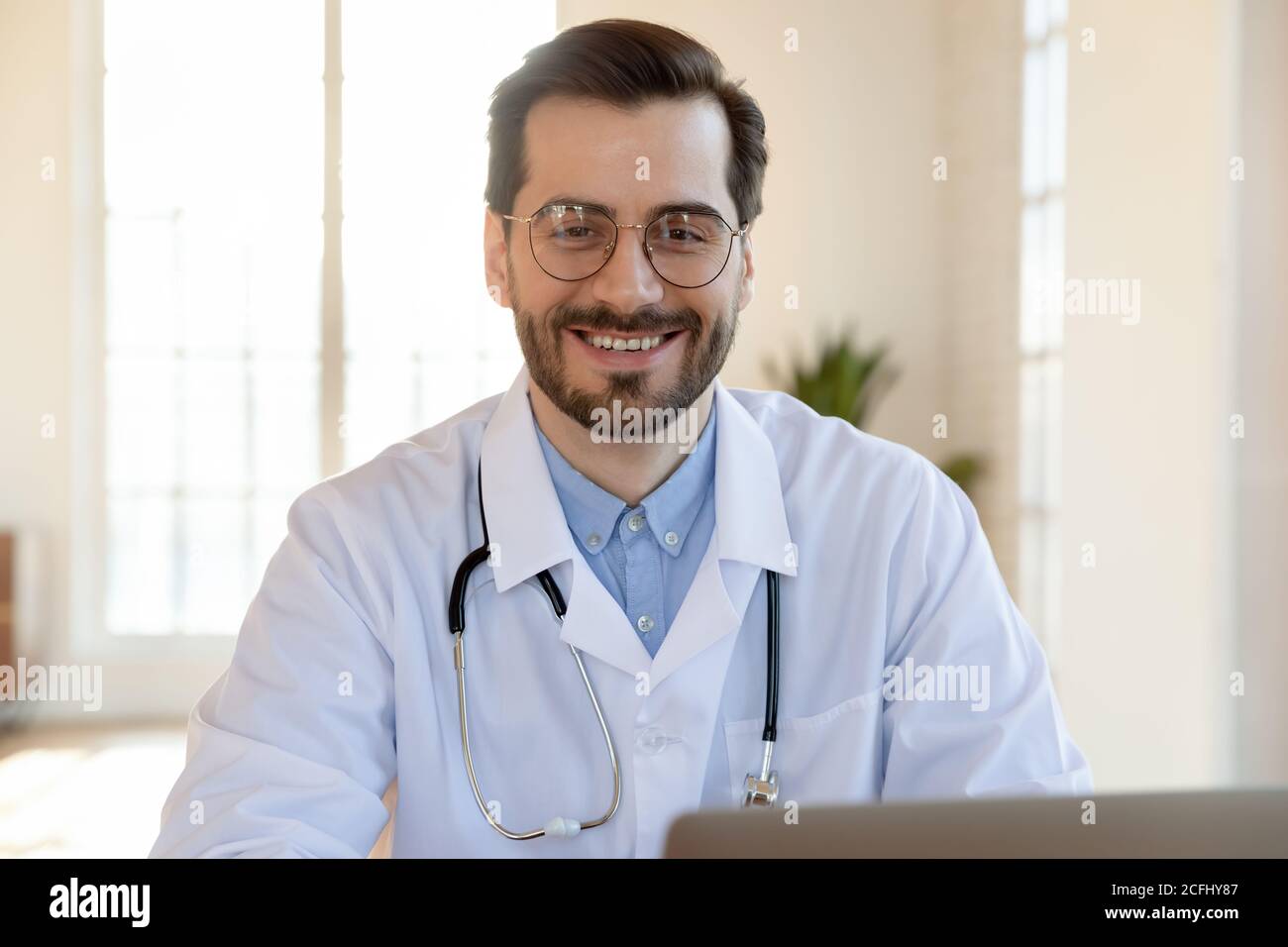 Head shot portrait smiling confident doctor wearing glasses and uniform ...