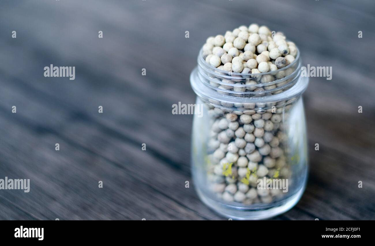 Pepper in a jar on wood background Stock Photo - Alamy