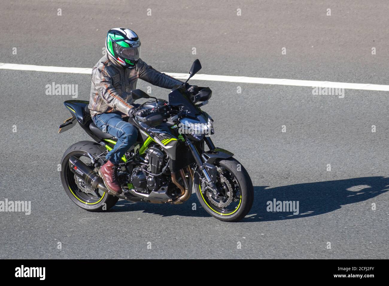 A yellow striped 900cc motorbike Akrapovic exhaust; Motorbike rider ...