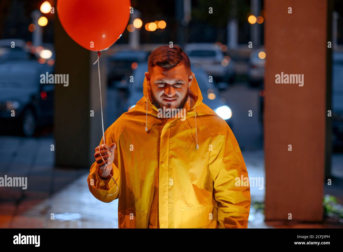 Scary man with balloon walking in night park Stock Photo - Alamy