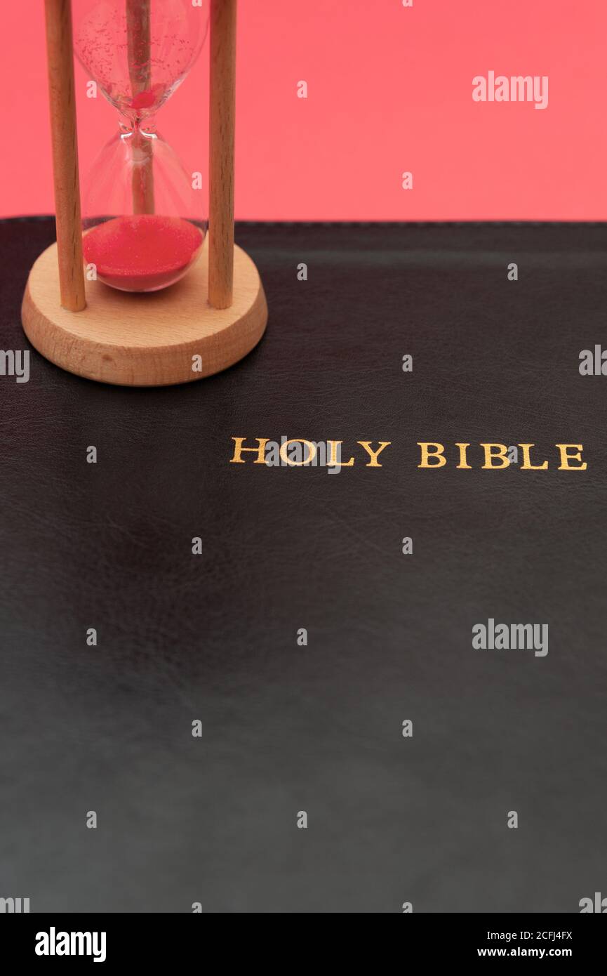 Holy Bible, the Word of God with hourglass. Isolated on red background ...