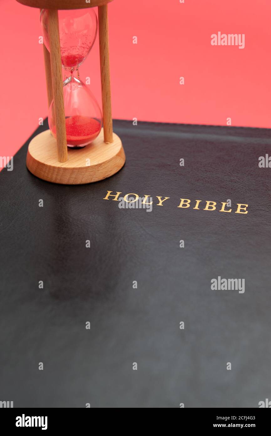 Holy Bible, the Word of God with hourglass. Isolated on red background ...