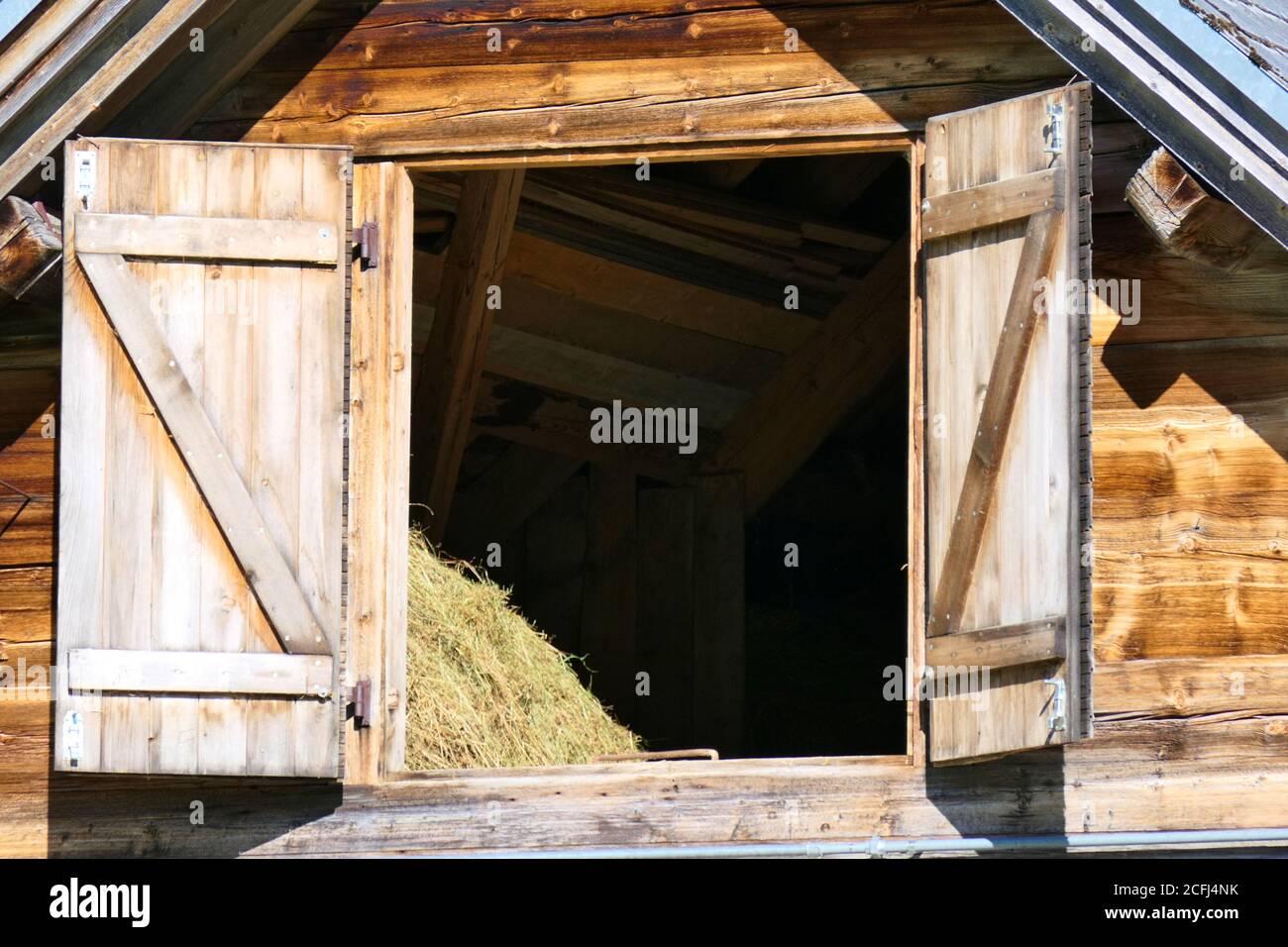Original wooden house with open window to the hayloft where hay is ...