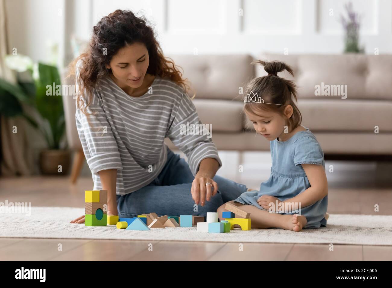 Mom and daughter play with toy blocks sit on floor Stock Photo - Alamy