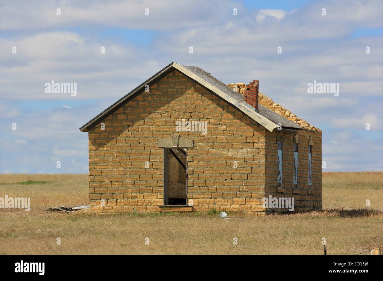Old Limestone School in a pasture with prairie grass,blue sky, and ...
