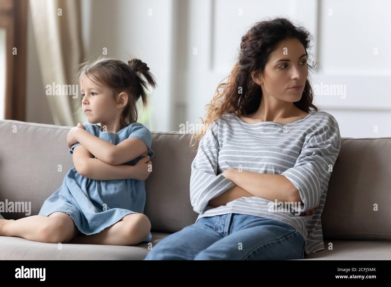Mother disobedient daughter sit apart on sofa feeling discontent Stock ...