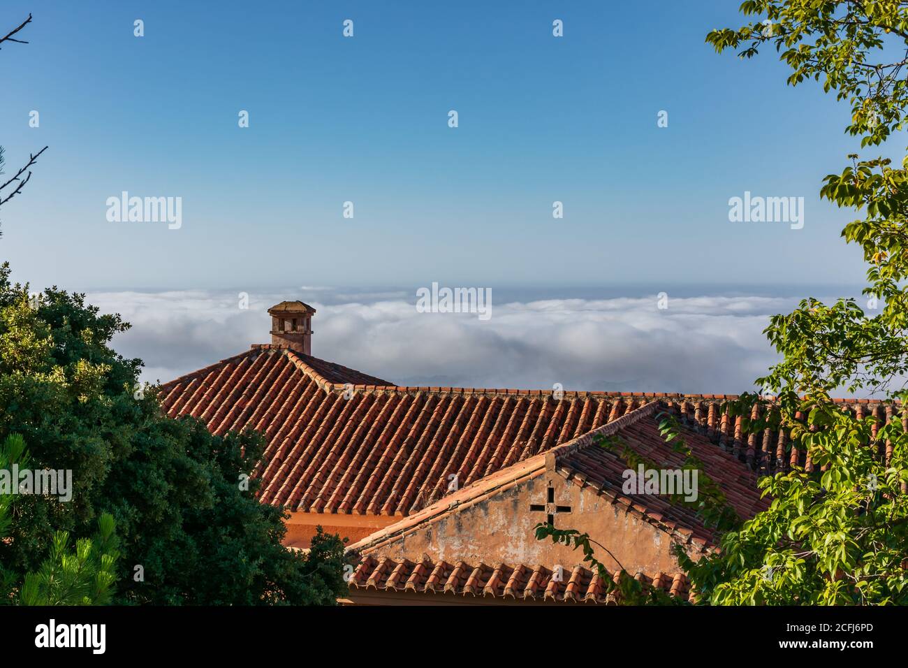 View of a roof of a mountain house with the clouds at the same height ...