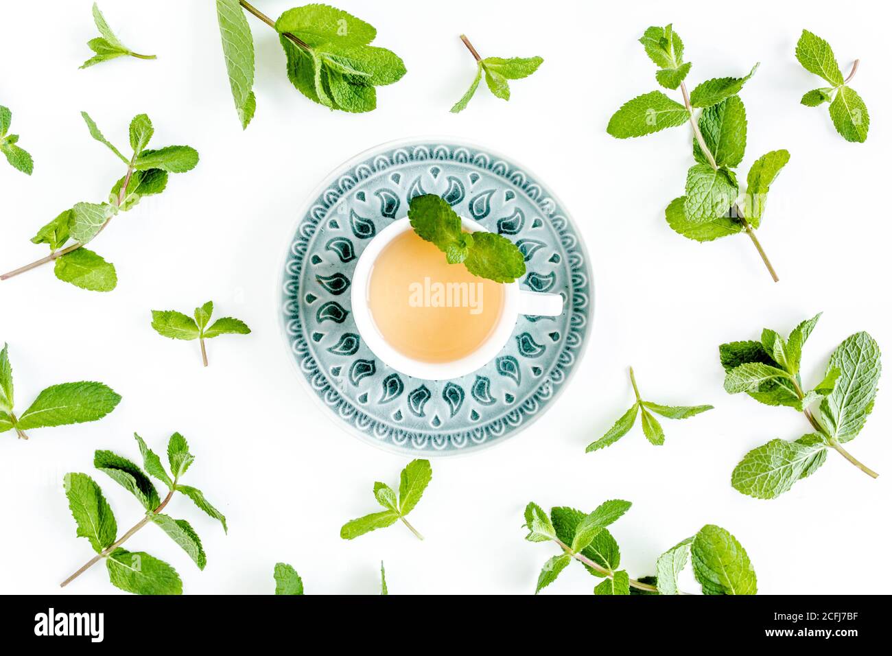 Mint tea with frame made of mint leaves isolated on white background ...