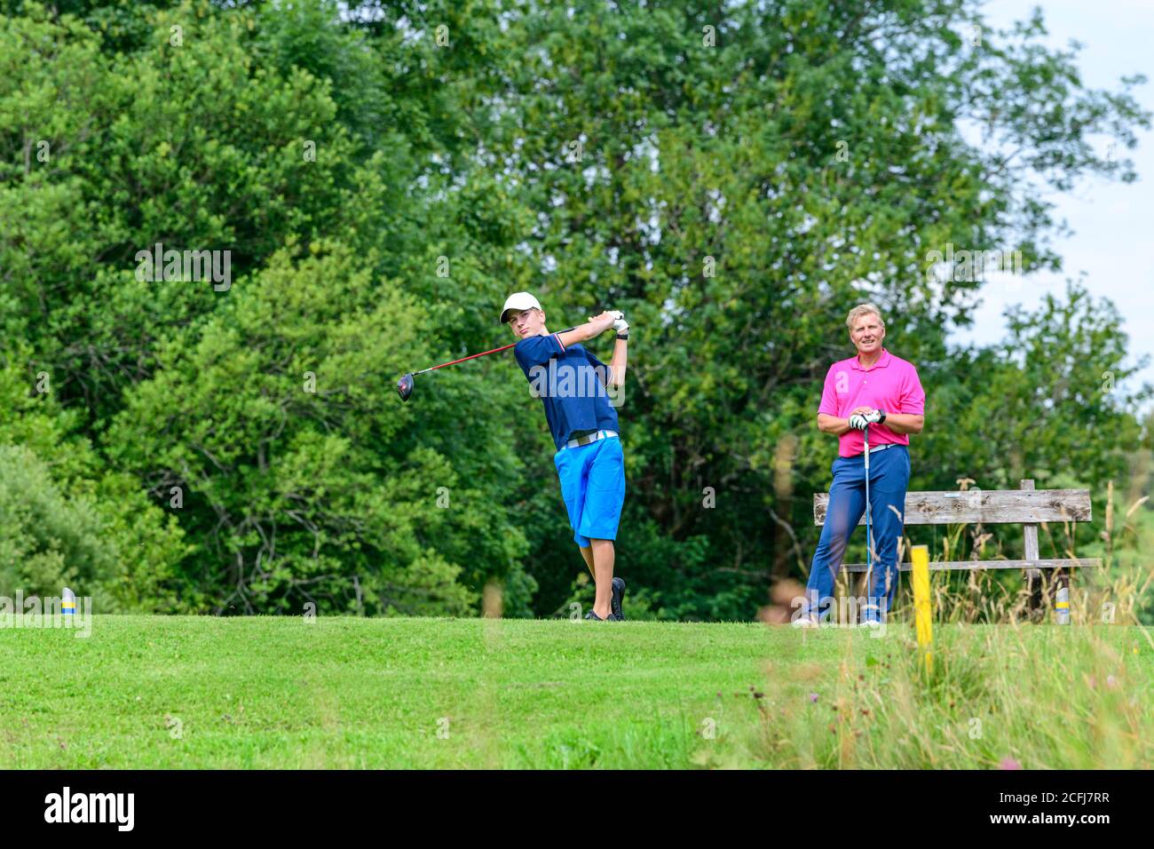 A group of golfers on a golf course in the Allgäu, playing golf in a ...