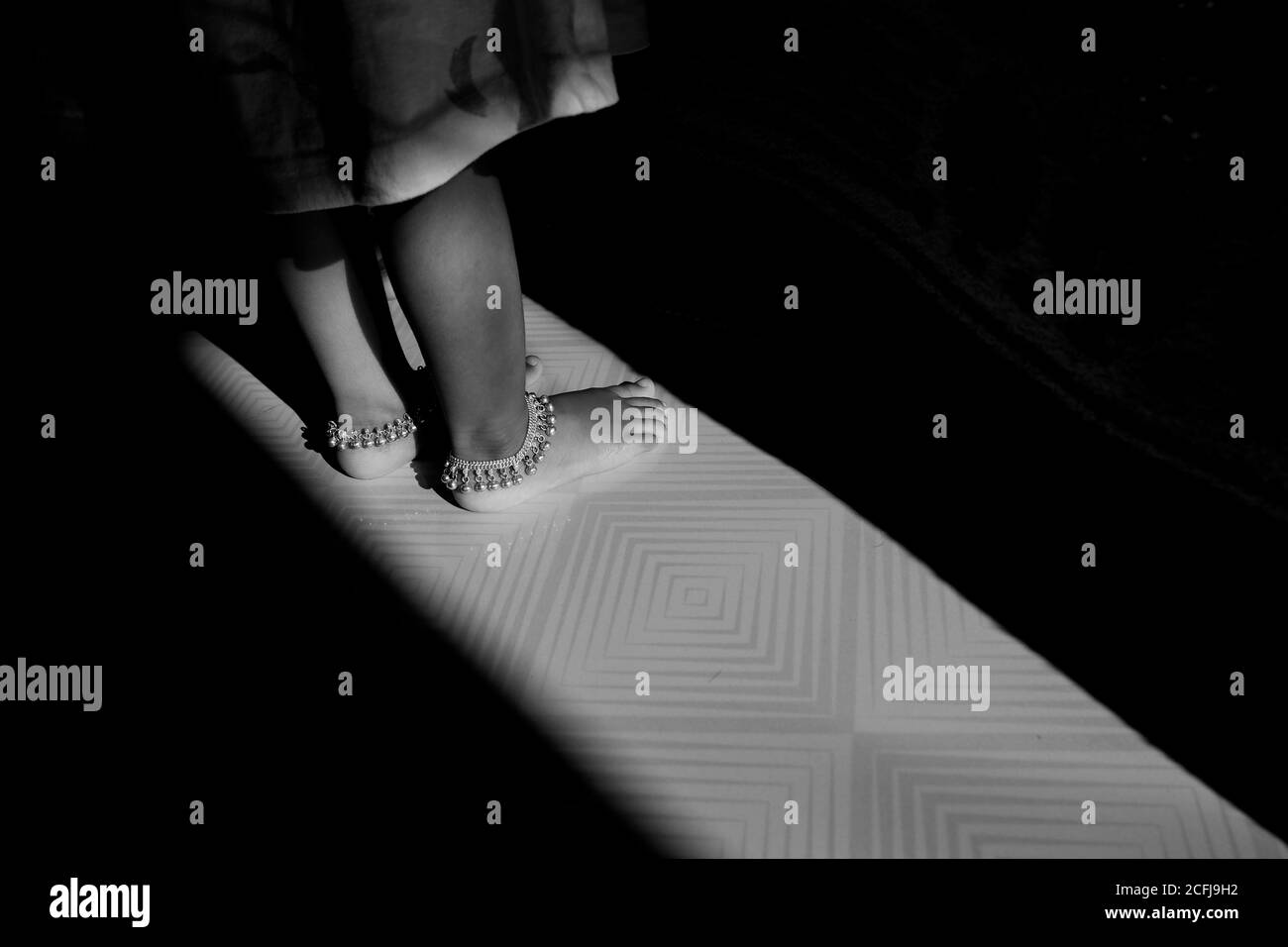 a girl child legs & anklet chain isolated on floor Stock Photo - Alamy