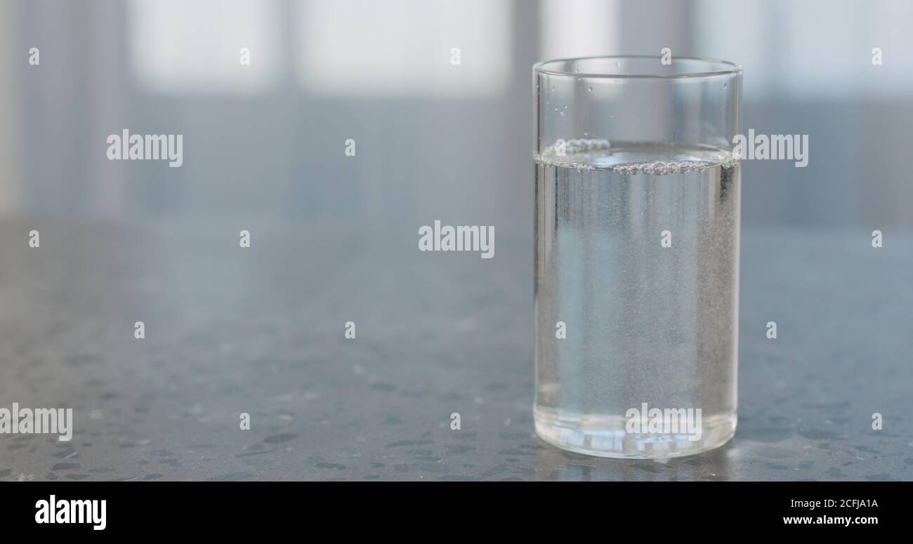 clean fresh sparkling water in beaker glass on concrete countertop ...