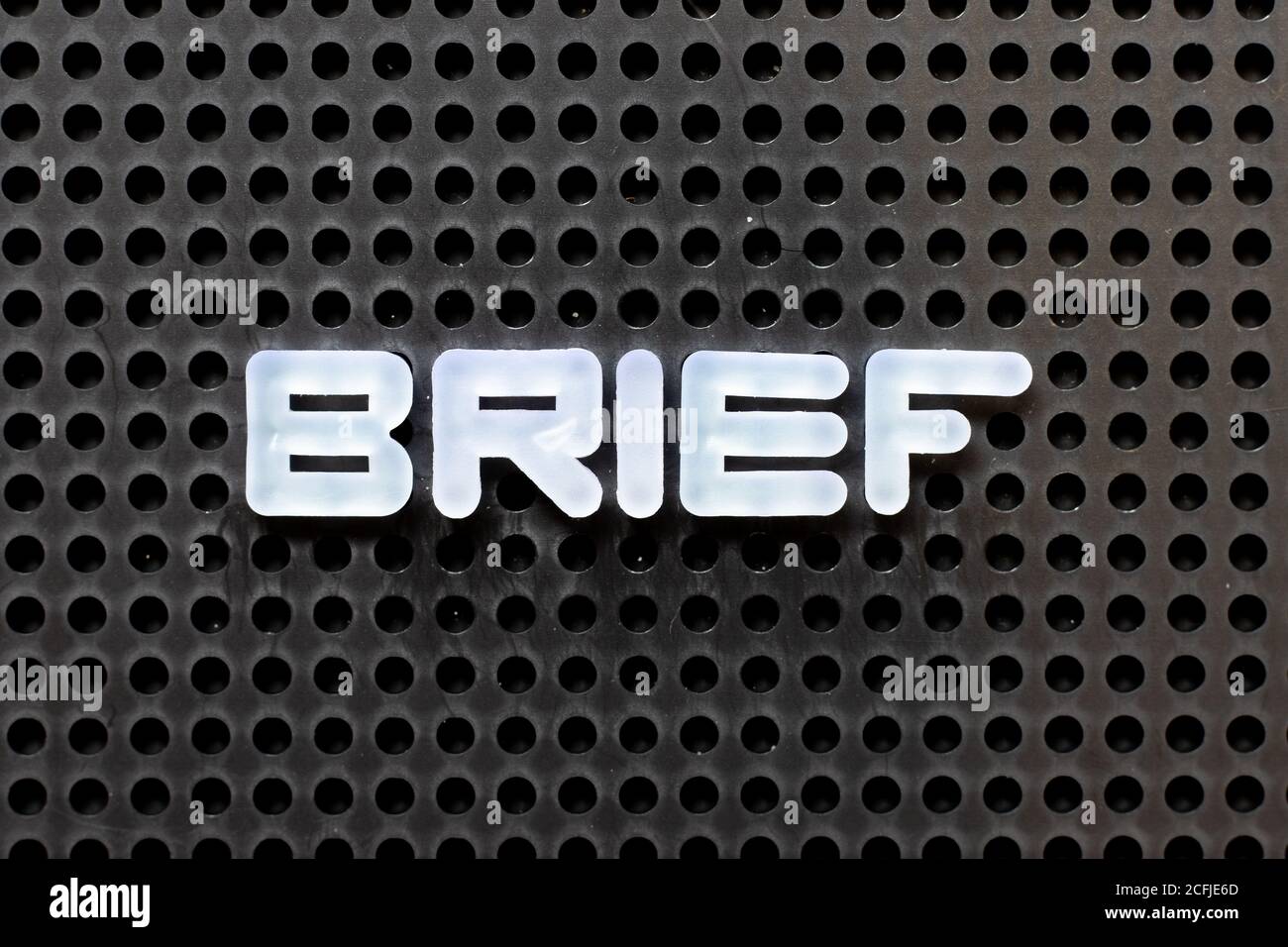 White color alphabet with word brief on black pegboard background Stock ...
