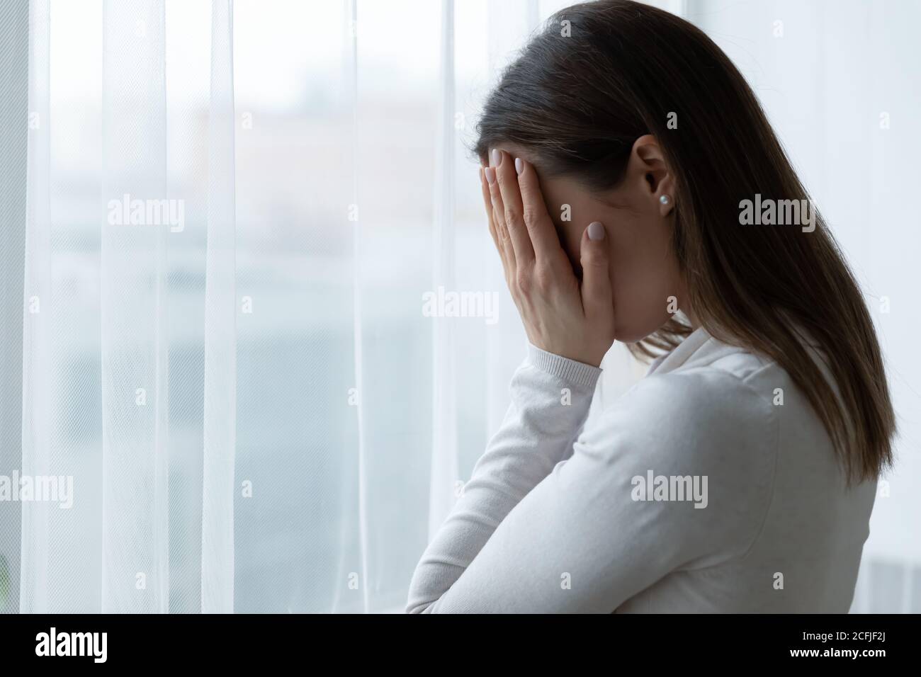 Desperate stressed woman hiding face in hands, suffering from ...