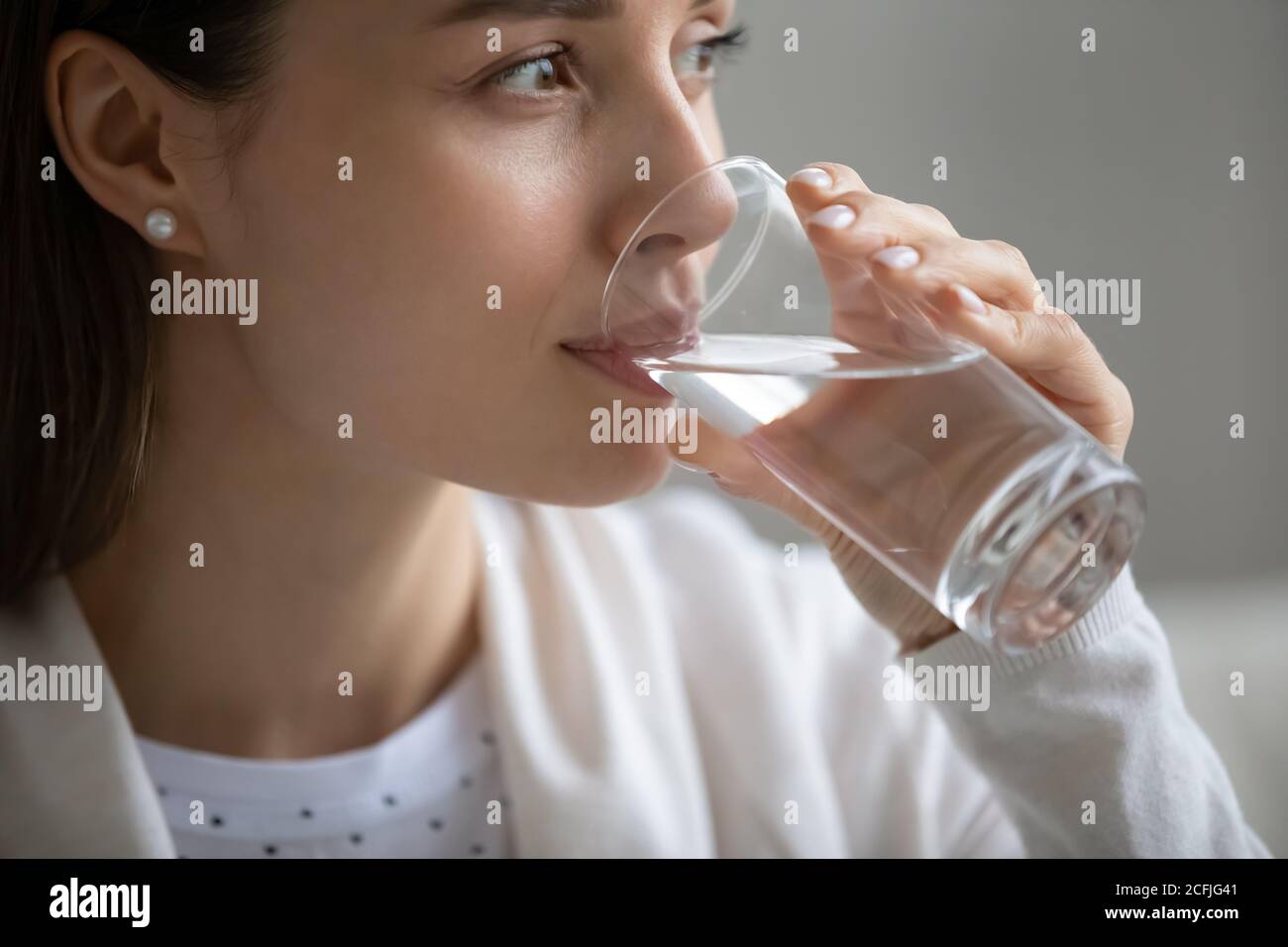 Happy pleasant young woman enjoying drinking water Stock Photo - Alamy