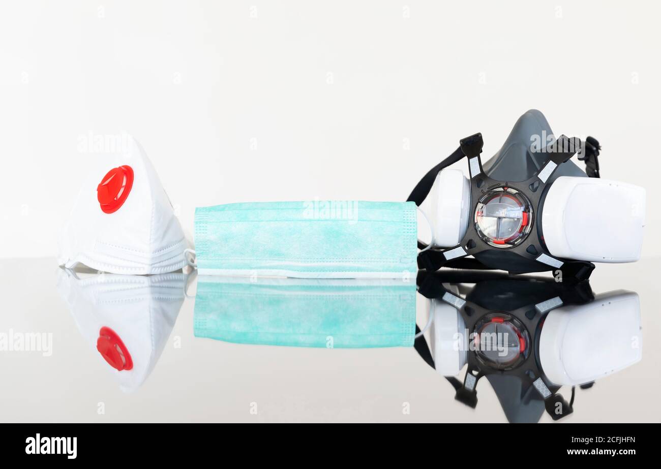 Selection of different type of face masks laid on the glass surface ...