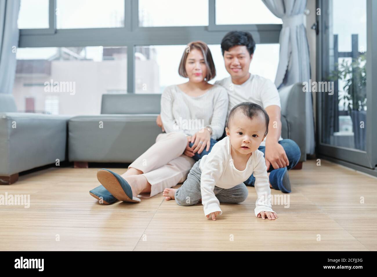 Parents and crawling baby Stock Photo - Alamy