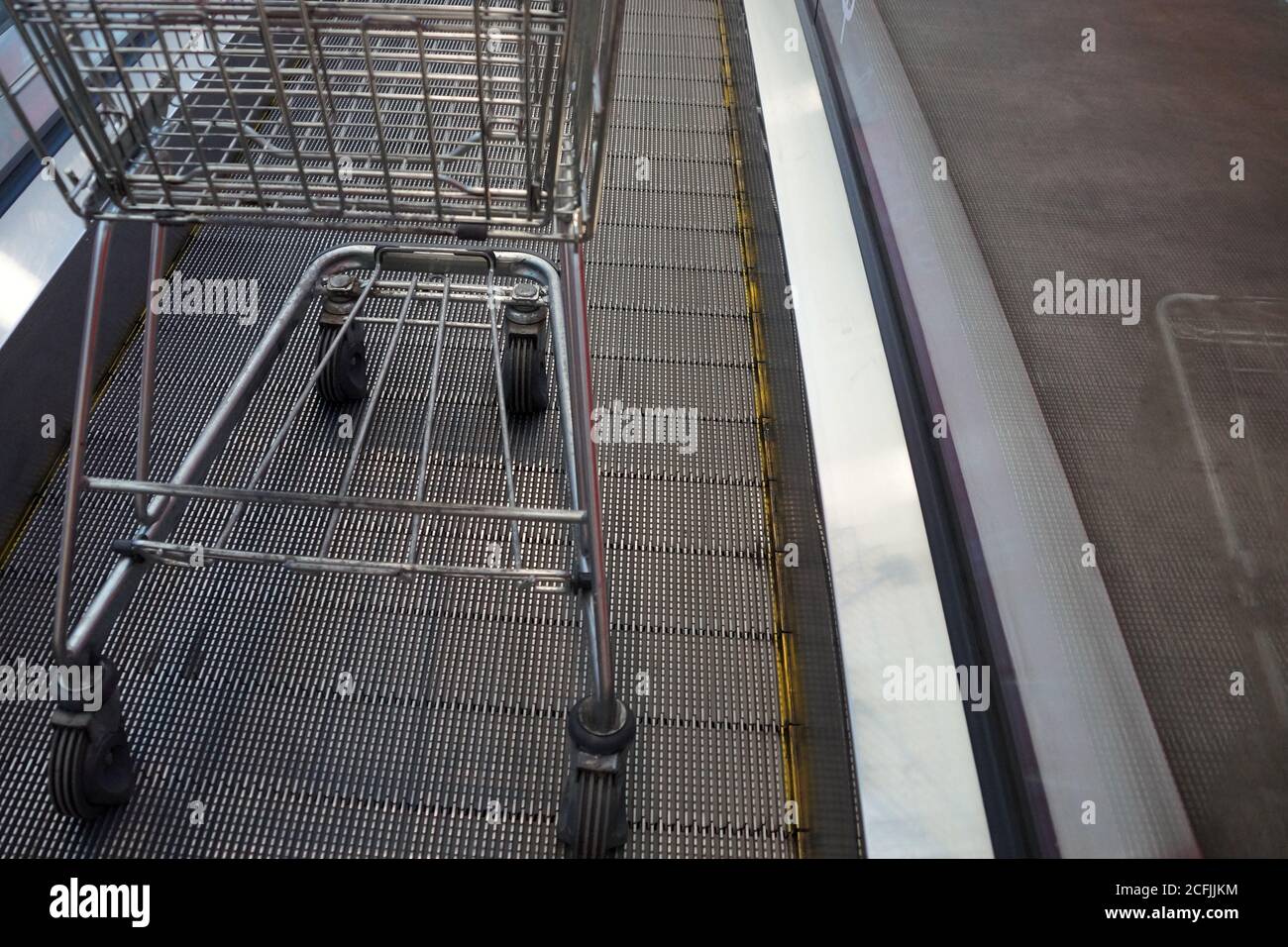 empty trolley on supermarket escalator Stock Photo - Alamy