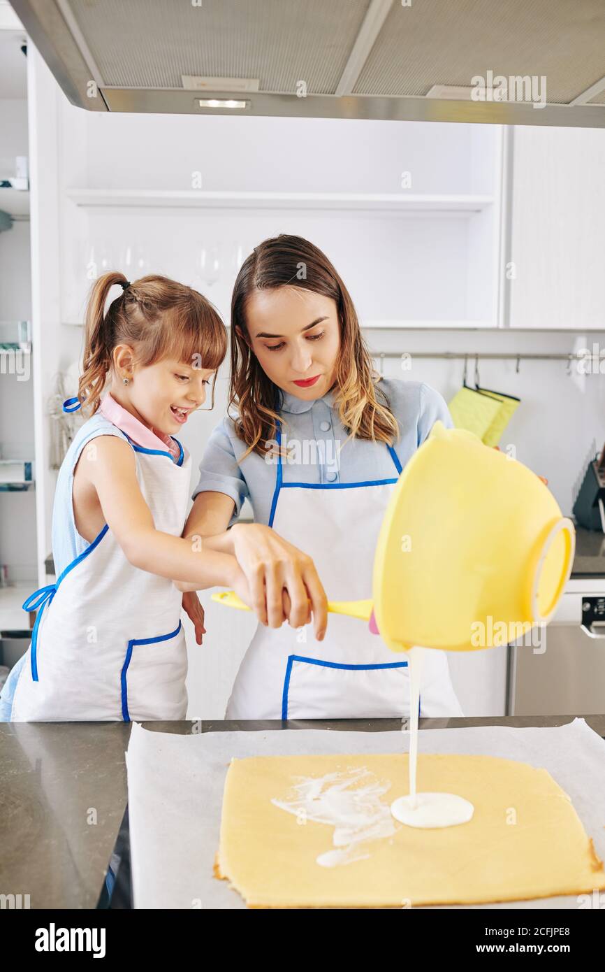 Putting cream frosting on cake Stock Photo - Alamy