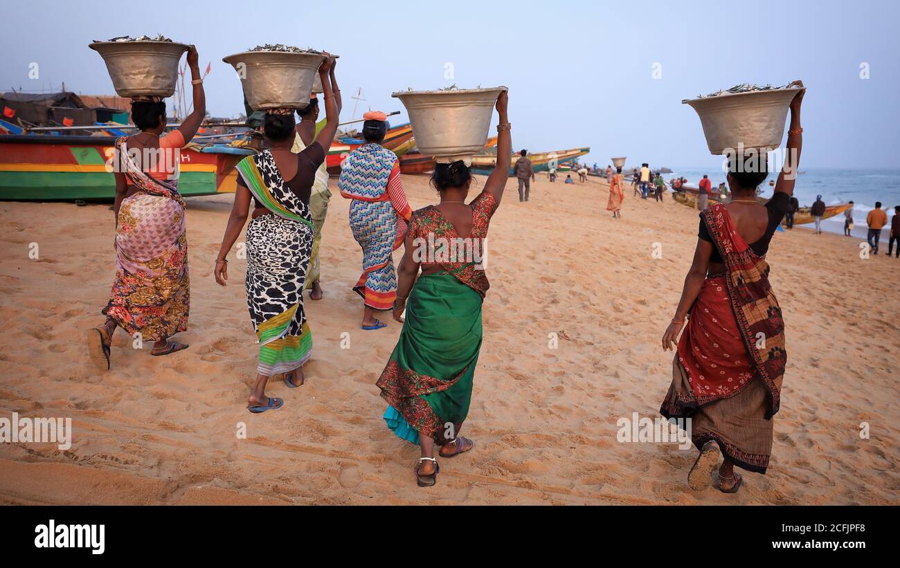 Market women wait for fish on the beach near the traditional fishing ...