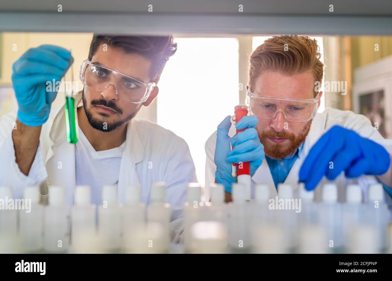 Group of medical research scientists collectively working in laboratory ...